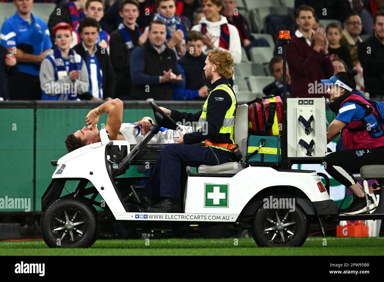 Charlie Comben of North Melbourne is treated for an injury during the ...