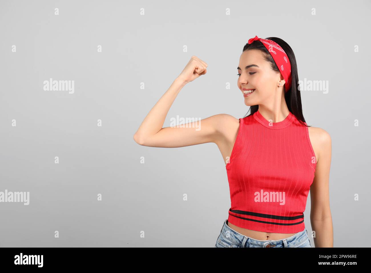 Strong woman as symbol of girl power on light grey background, space ...