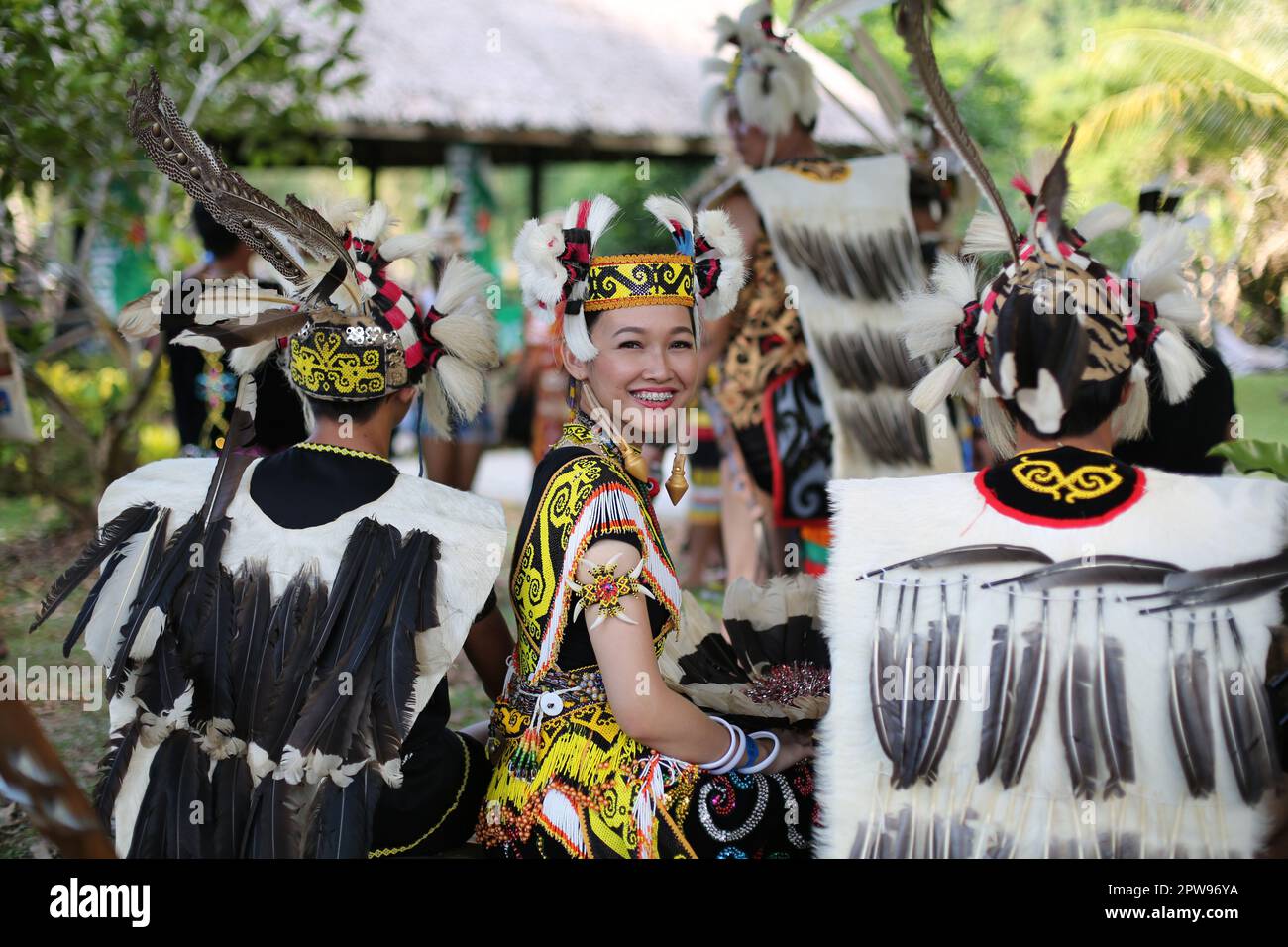 Charming Orang Ulu lass of Sarawak flanked by warriors adorned with ...