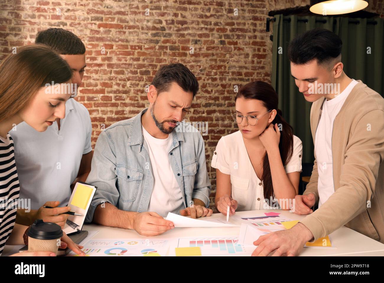 Team of employees working together in office Stock Photo - Alamy