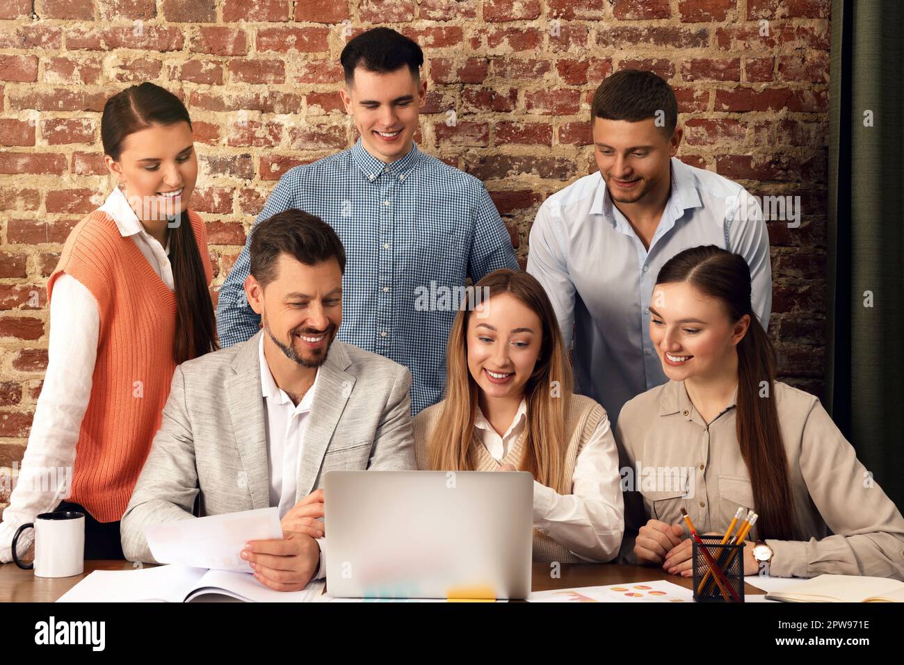 Team of employees working together in office Stock Photo - Alamy