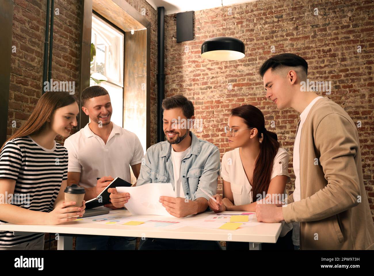 Team of employees working together in office Stock Photo - Alamy