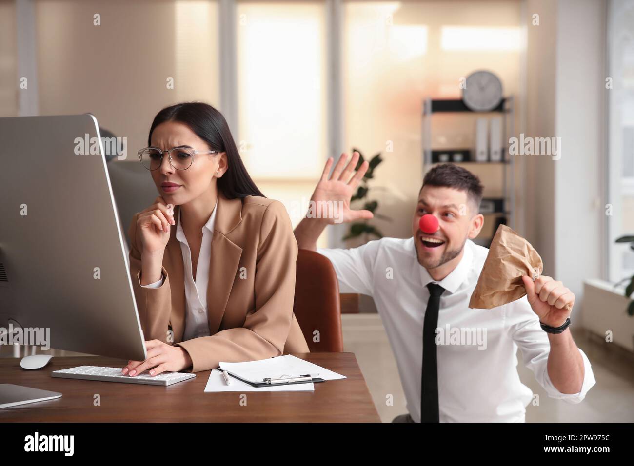 Man popping paper bag behind his colleague in office. Funny joke Stock ...