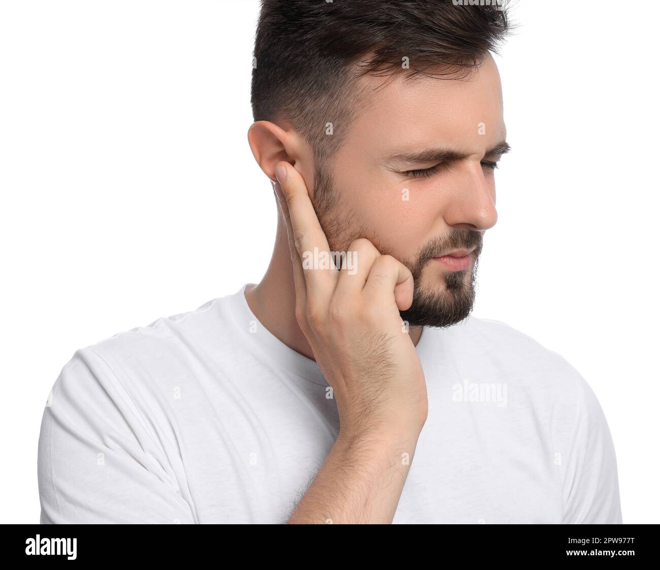 Young man suffering from ear pain on white background Stock Photo - Alamy