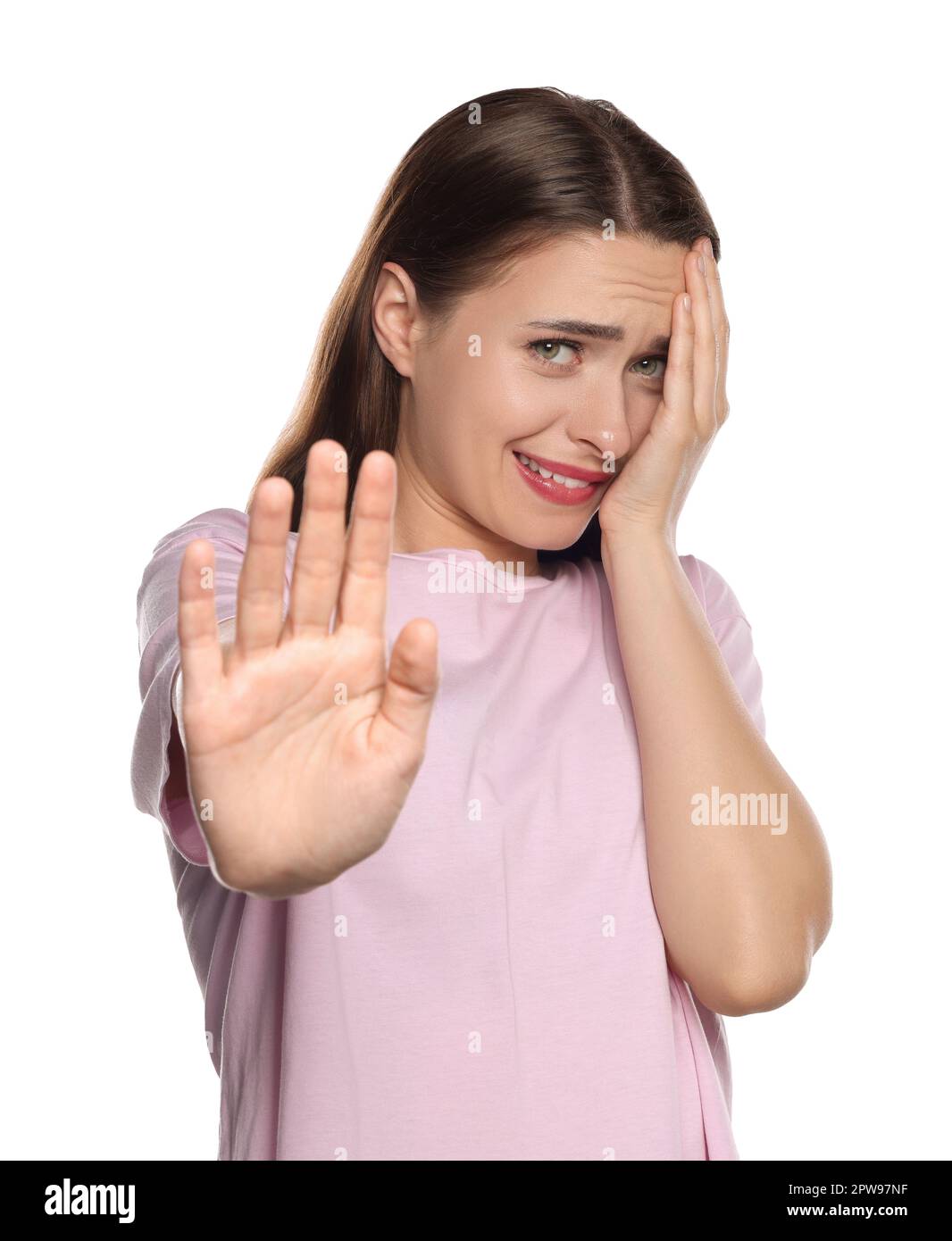 Embarrassed young woman covering face with hand on white background ...