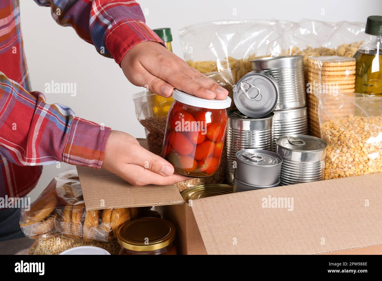 Man taking food out from donation box, closeup Stock Photo - Alamy