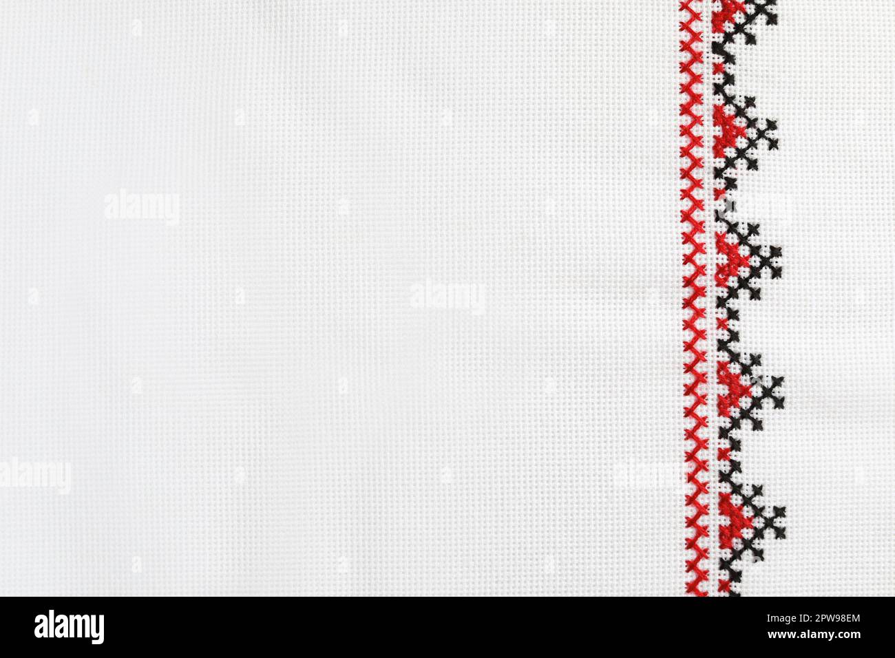 Traditional Ukrainian embroidery on white canvas as background, closeup ...