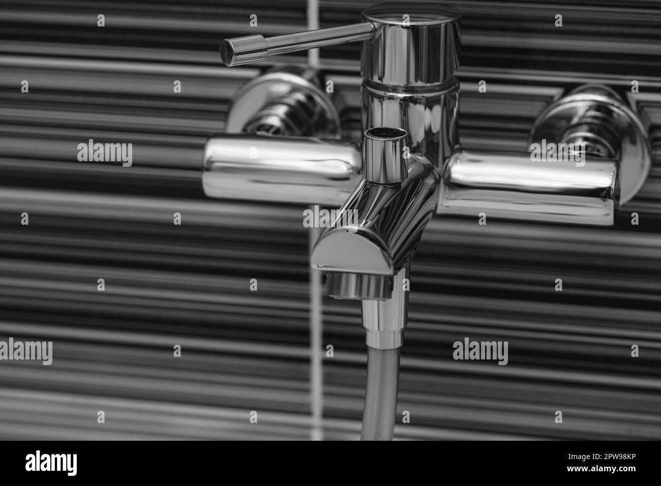 Shiny Bath Water Tap Installed On Black And White Wall Space For Text