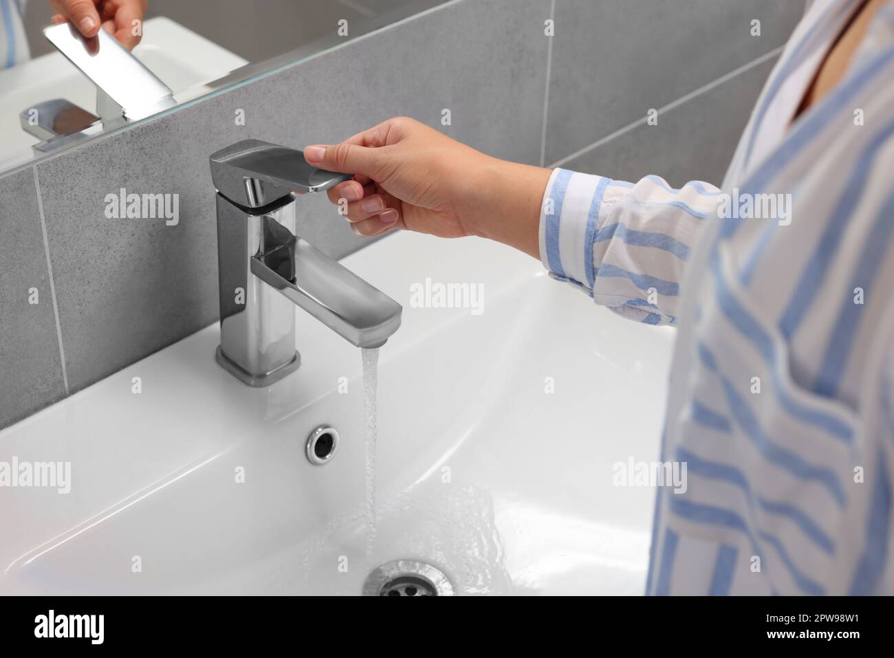 Woman open wash basin tap hi-res stock photography and images - Alamy