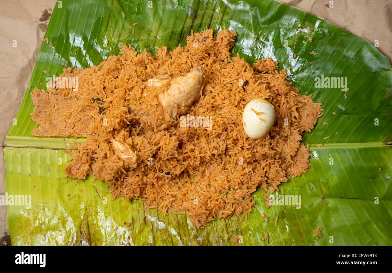 Hot chicken biryani with egg and chicken pieces served on banana leaf ...