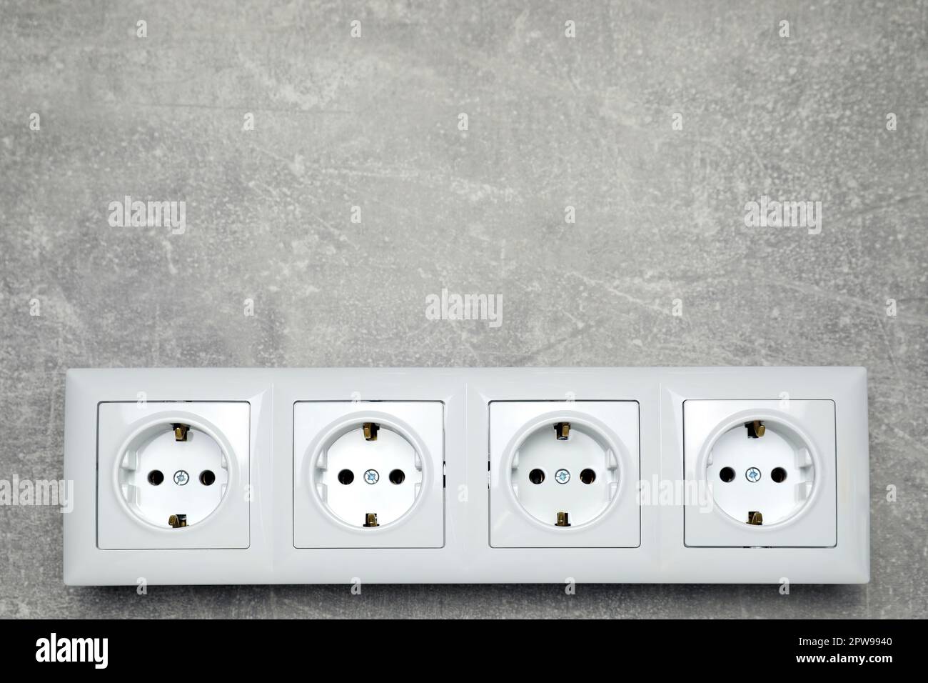 Modern plastic power socket on grey table, top view. Space for text ...