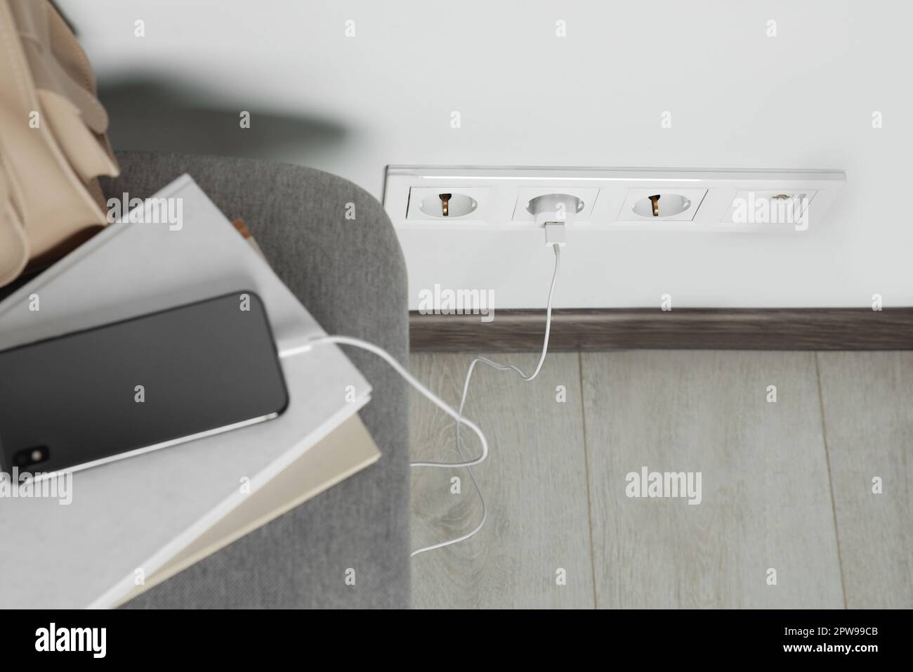 Electric power outlet sockets with charger on white wall, above view ...