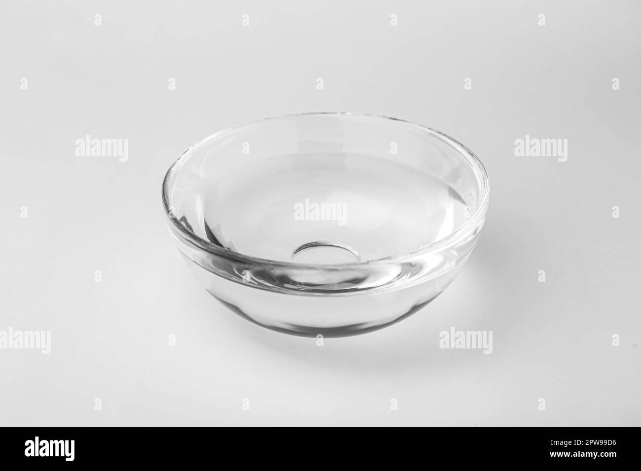 Glass bowl full of water on white background Stock Photo - Alamy