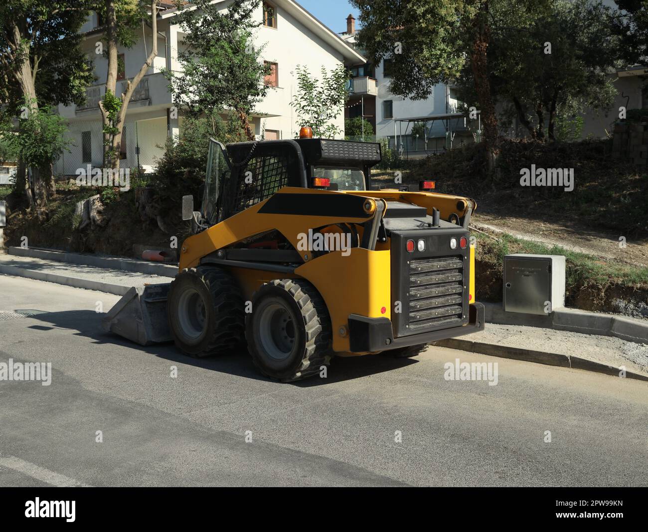Modern skid loader on city street. Road repair Stock Photo - Alamy