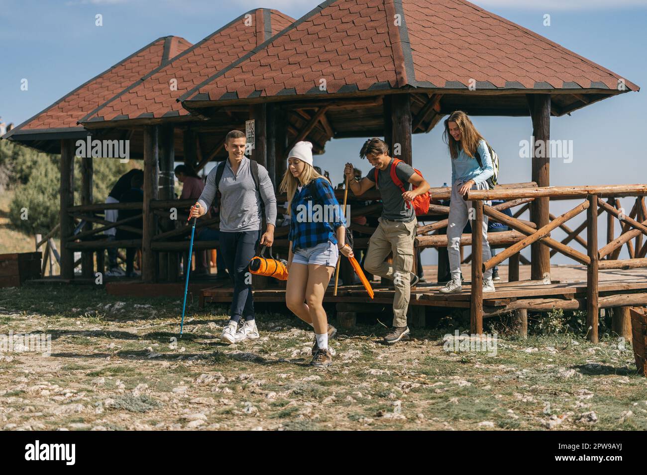 Four hikers walking away from the wooden bench Stock Photo - Alamy