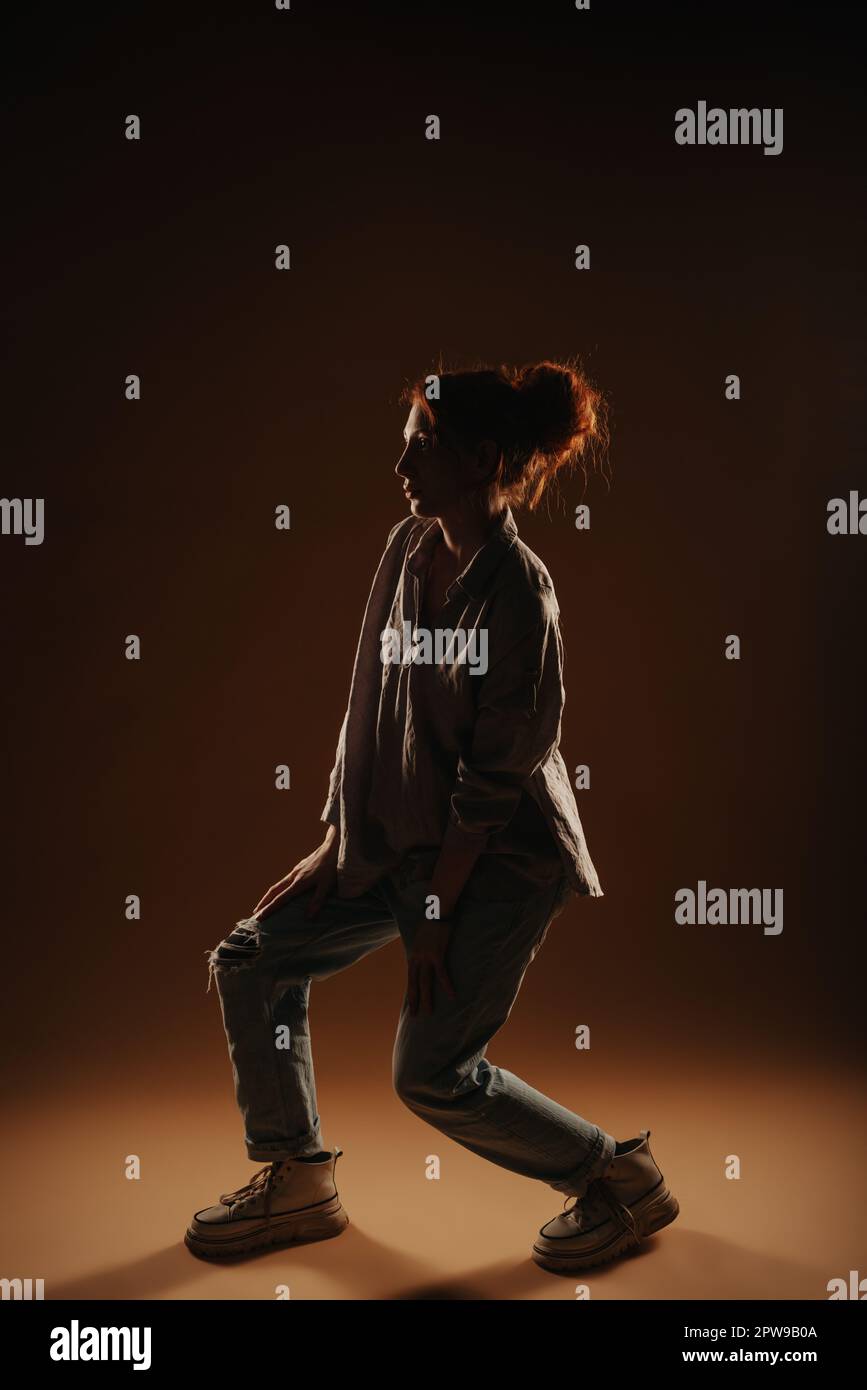 Beautiful silhouette of a ginger girl posing while standing at the ...