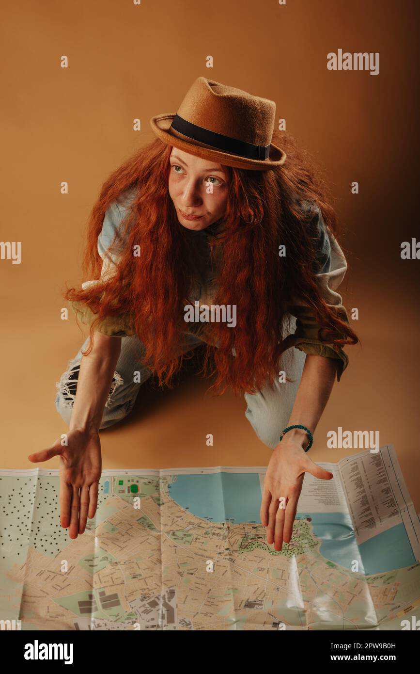 Close up of beautiful ginger girl showing the travel map while sitting ...