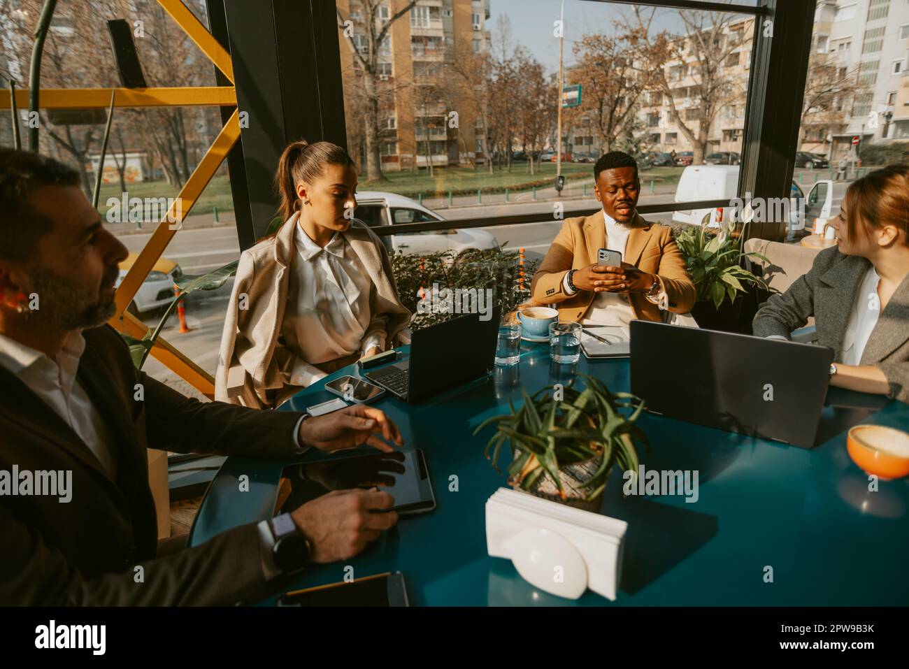 Group of four business people talking while sitting at the cafe Stock ...