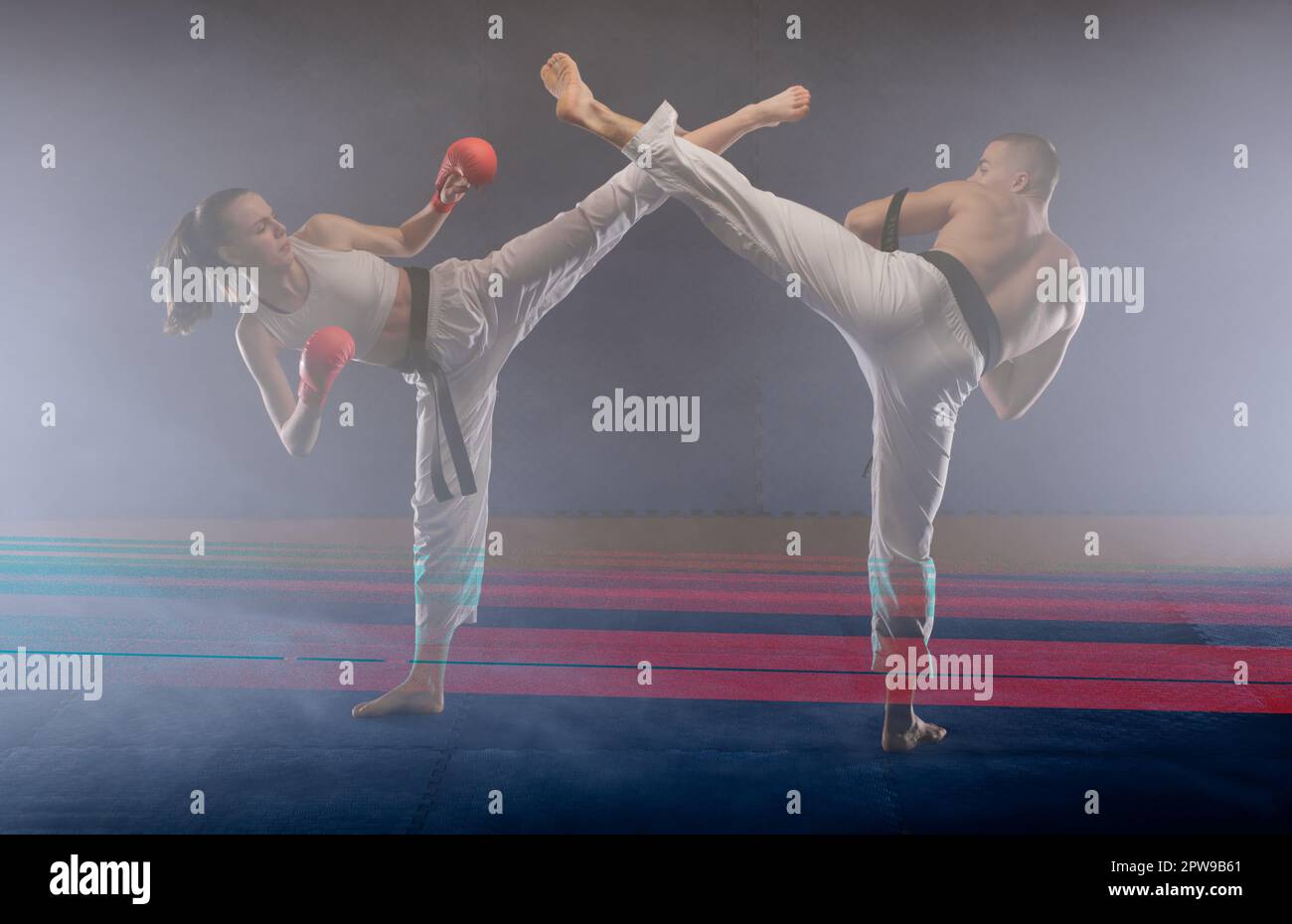 Two good looking karate friends doing some karate pose with their legs ...