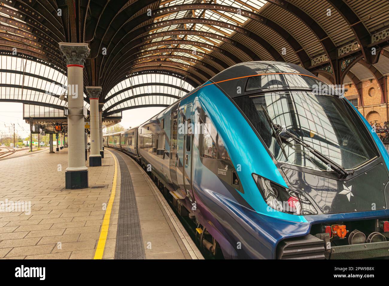 A train waits in a siding under a historic 19th Century metal canopy ...