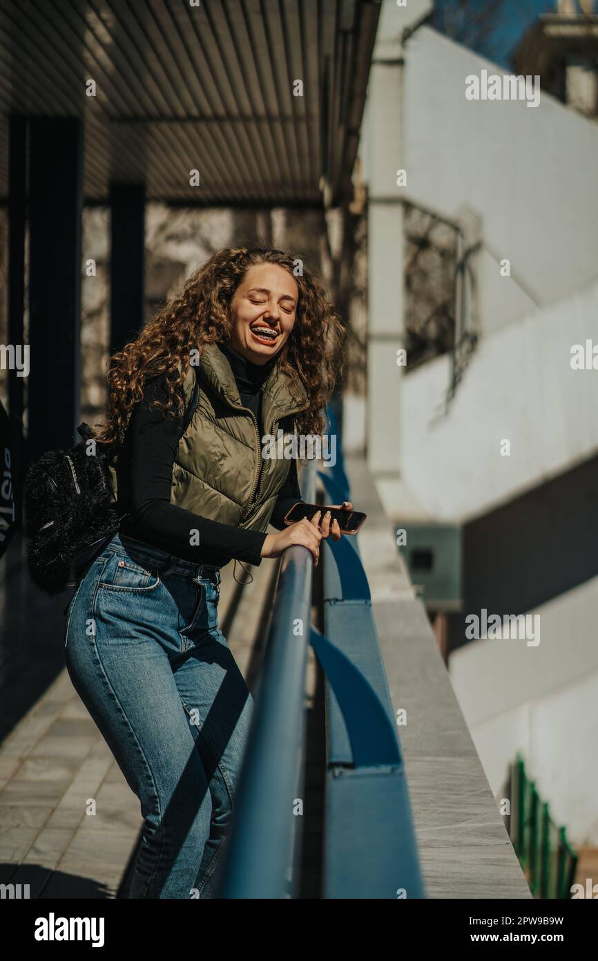 Beautiful girl saw something funny on her phone. She burst out laughing ...