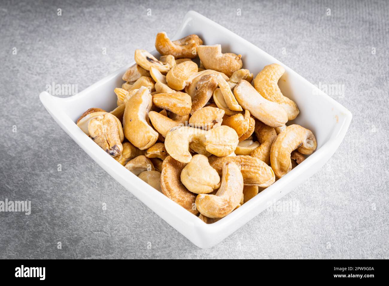 Cashew nuts in crockery pot on white wooden background Stock Photo - Alamy