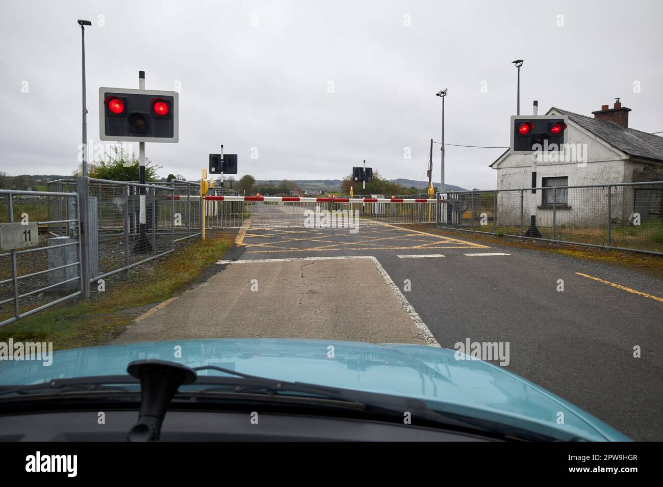 car waiting on road railway level crossing with barrier down county ...