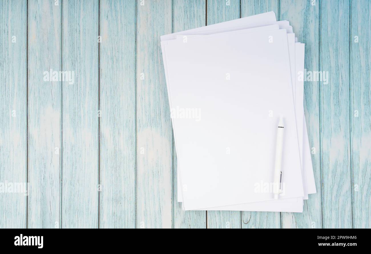 Top view of heap empty A4 paper and pec on blue wooden background for ...