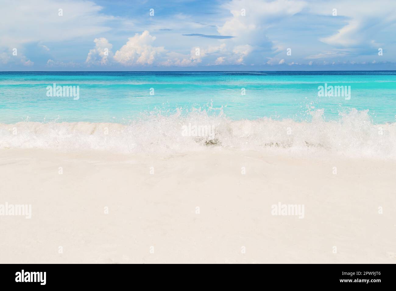 Bright sand beach and blue wave white foam from the sea with blue sky ...