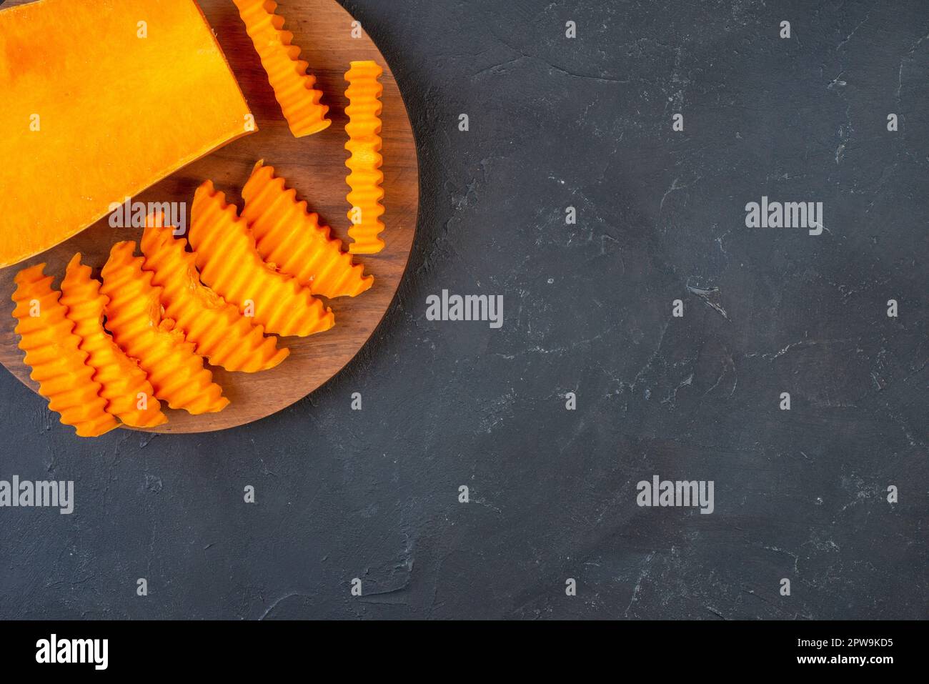 top view butternut squash chopped with zig-zag knife on wood board on ...
