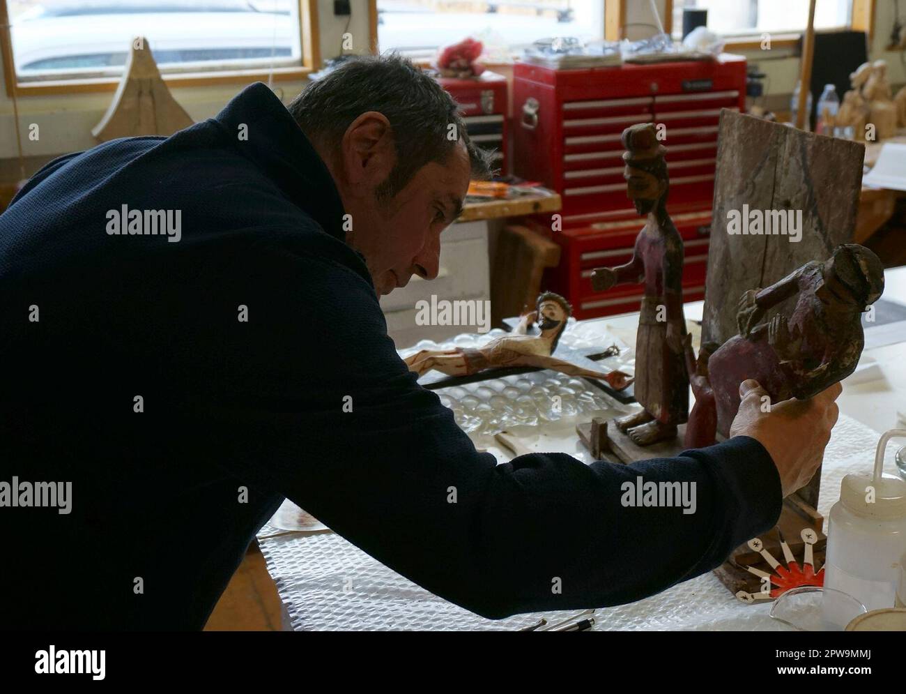 Victor Goler adjusts a holy family sculpture group in his studio ...