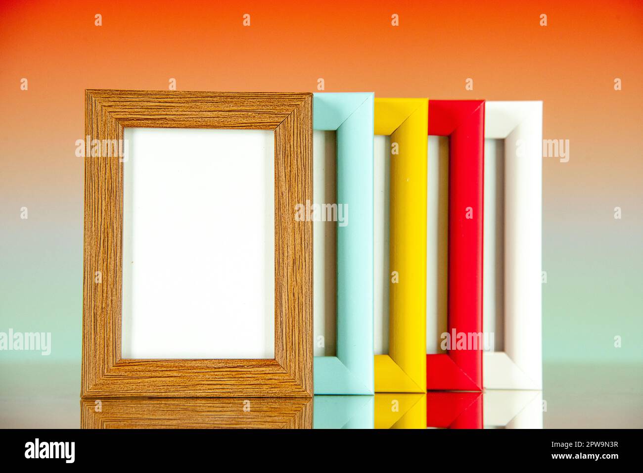 front view different picture frames with colored corners on light red ...