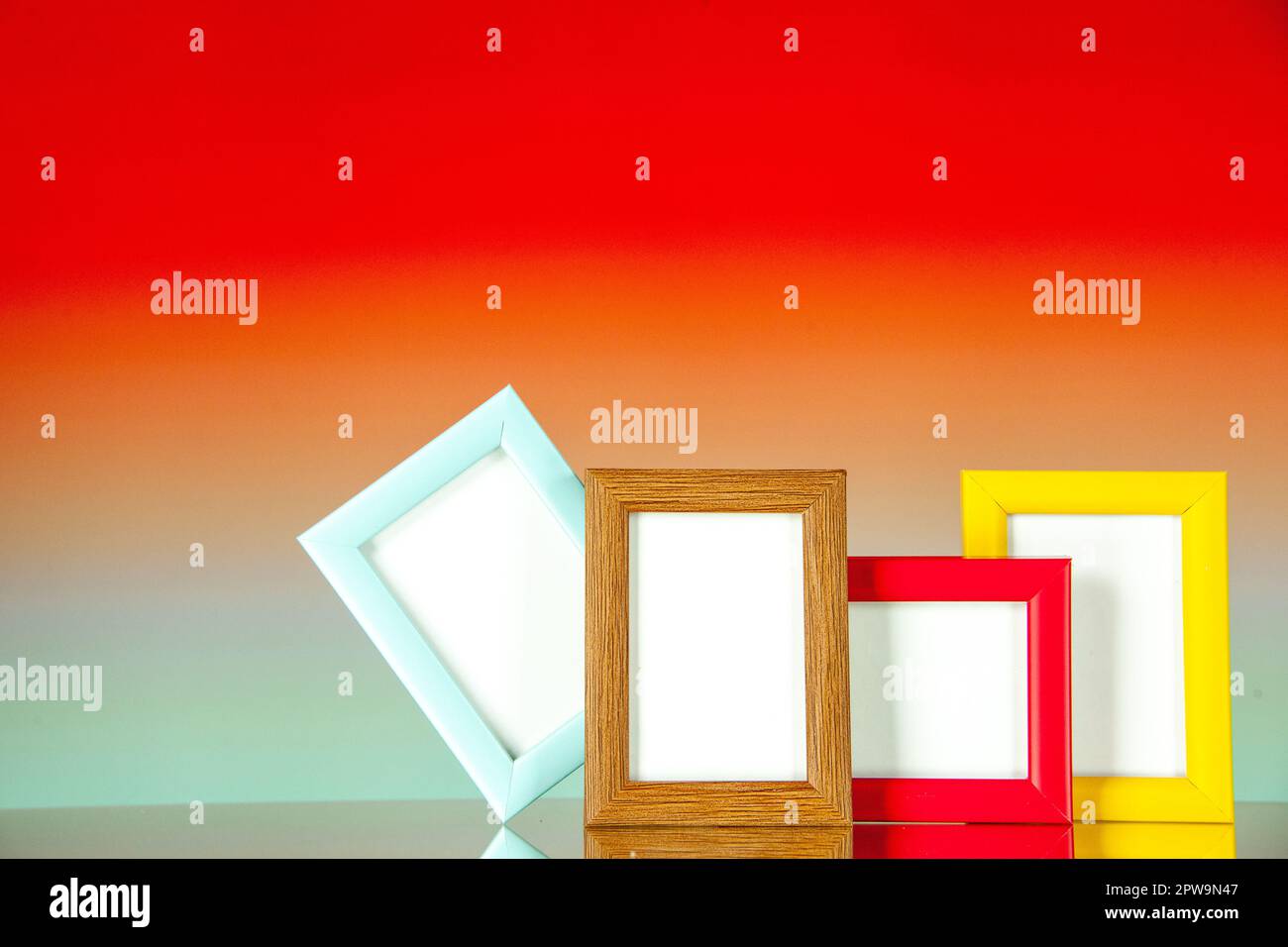 front view different picture frames with colored corners on light red ...
