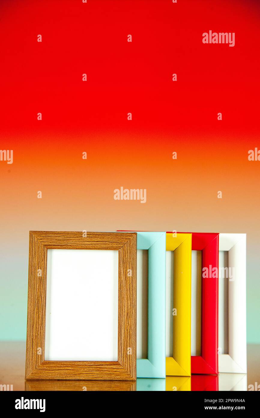 front view different picture frames with colored corners on light red ...