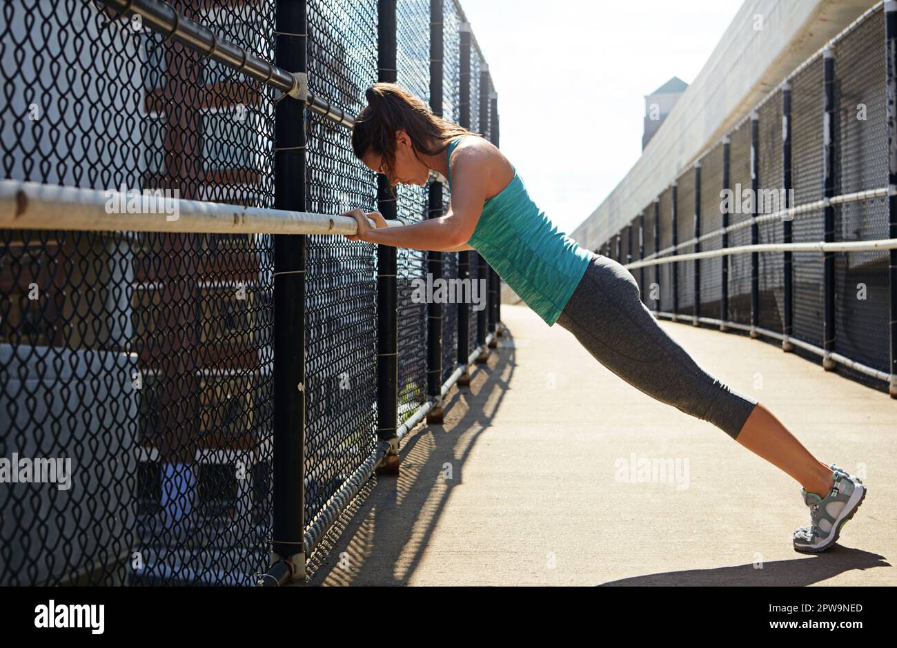 Working on her body. an attractive young woman stretching during her ...