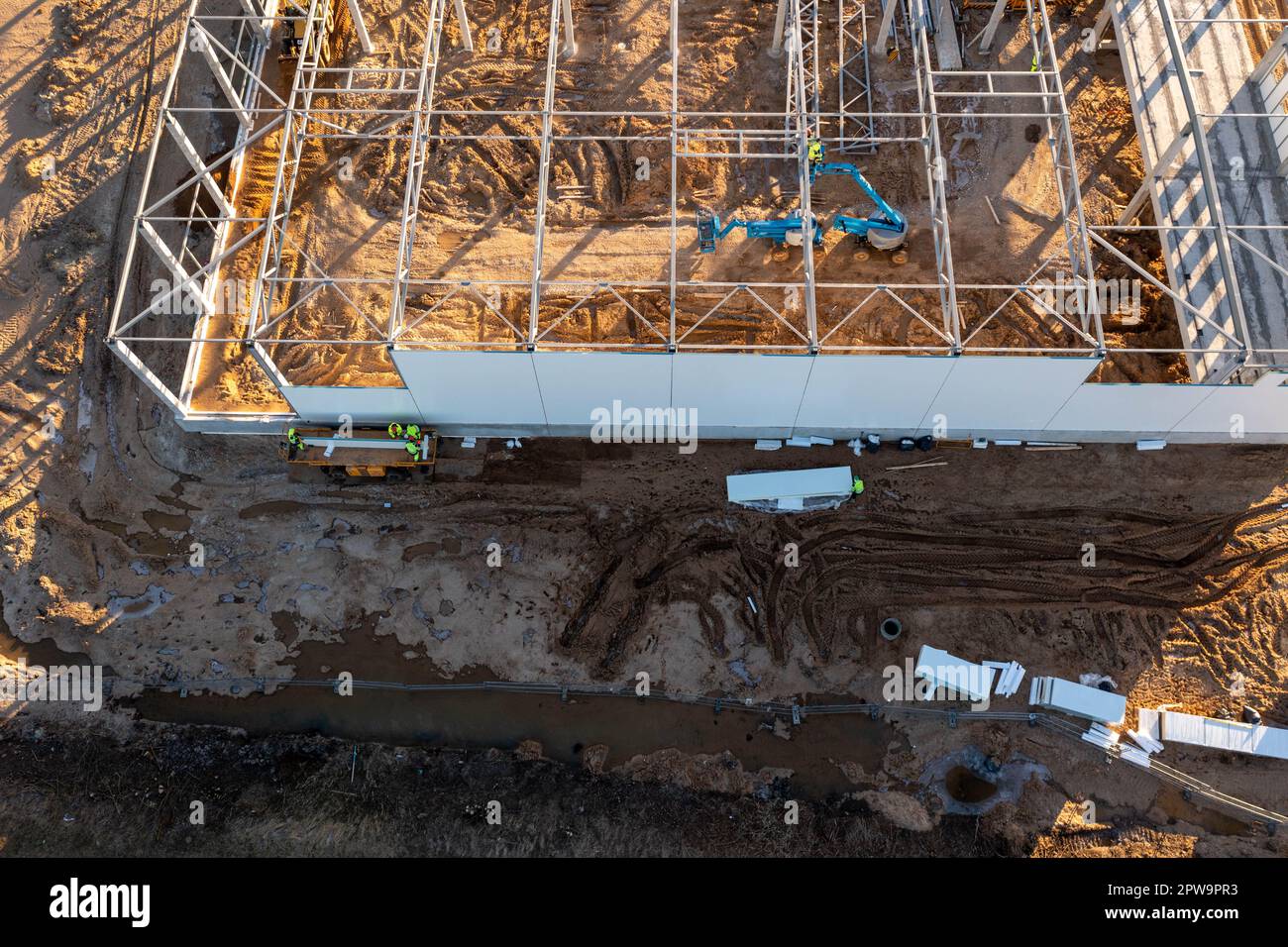 Drone photography of warehouse being built by construction workers ...