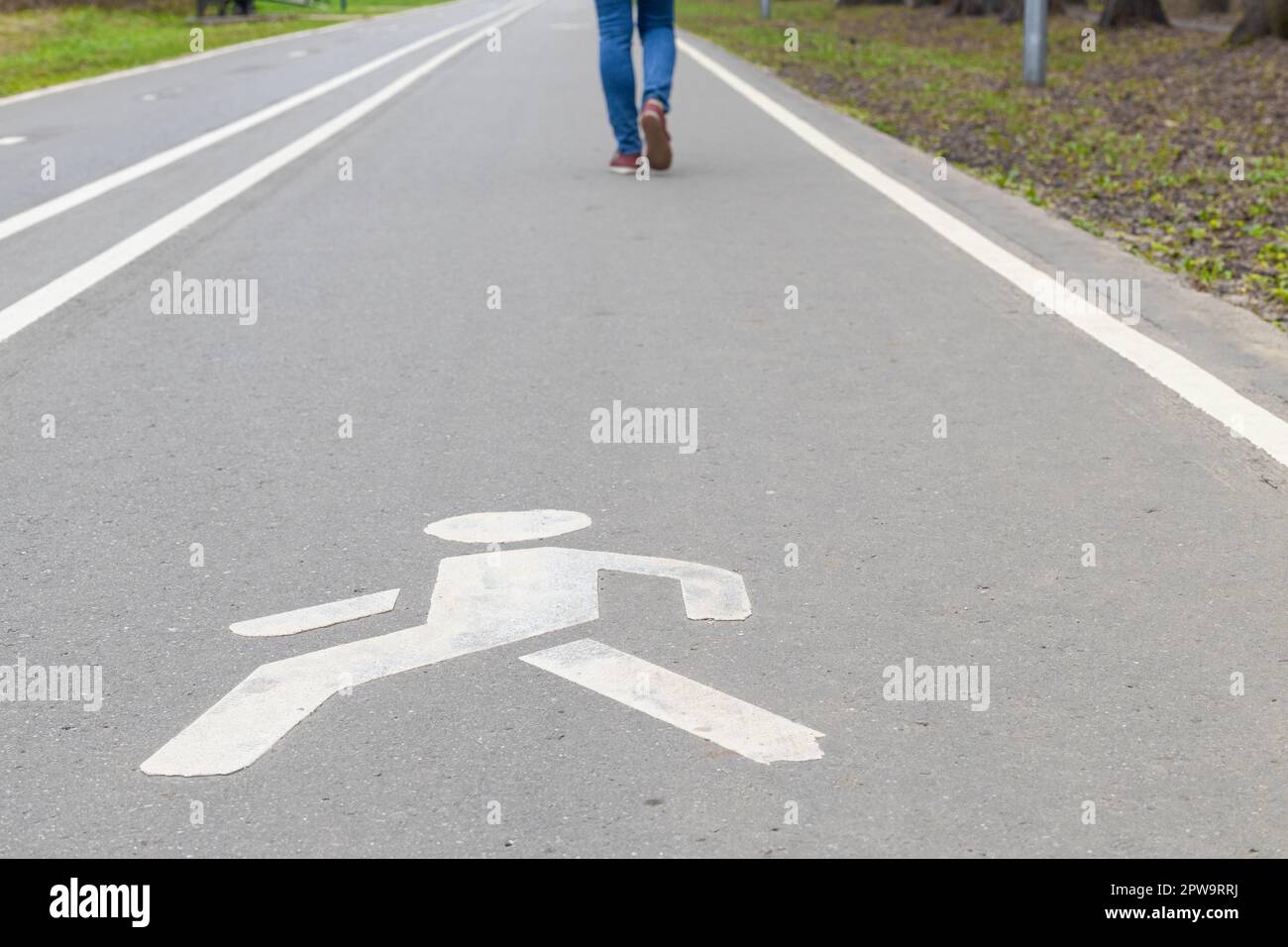 walking path in the park with a sign on the pavement. walking path in ...