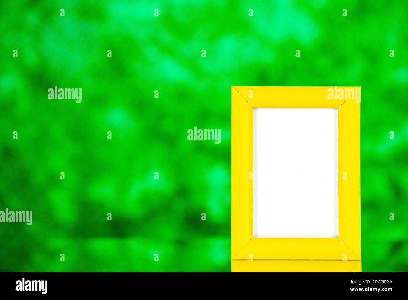 front view yellow picture frame on green background color shoot picture ...