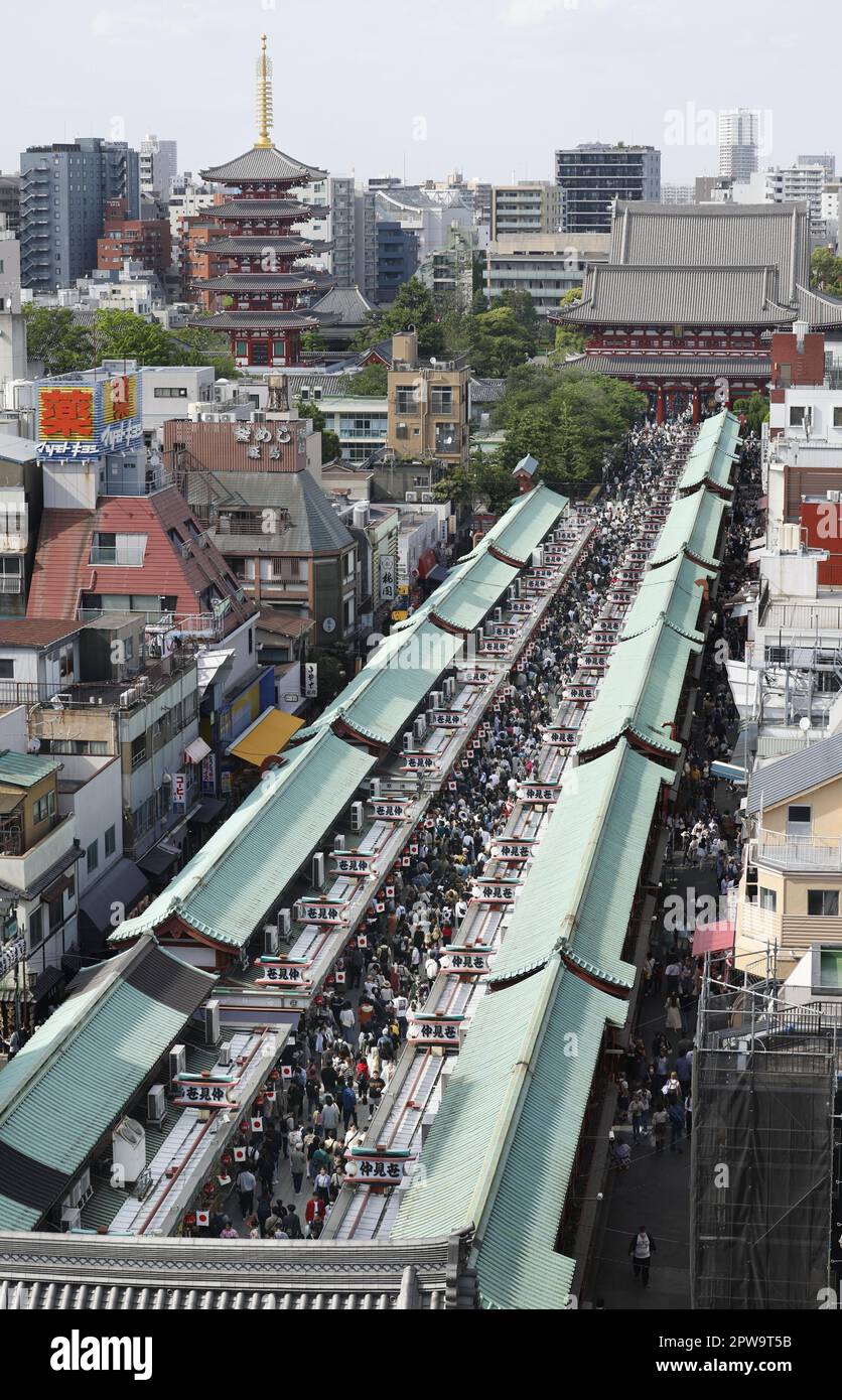 A shopping street in Tokyo's Asakusa area is crowded with people on ...
