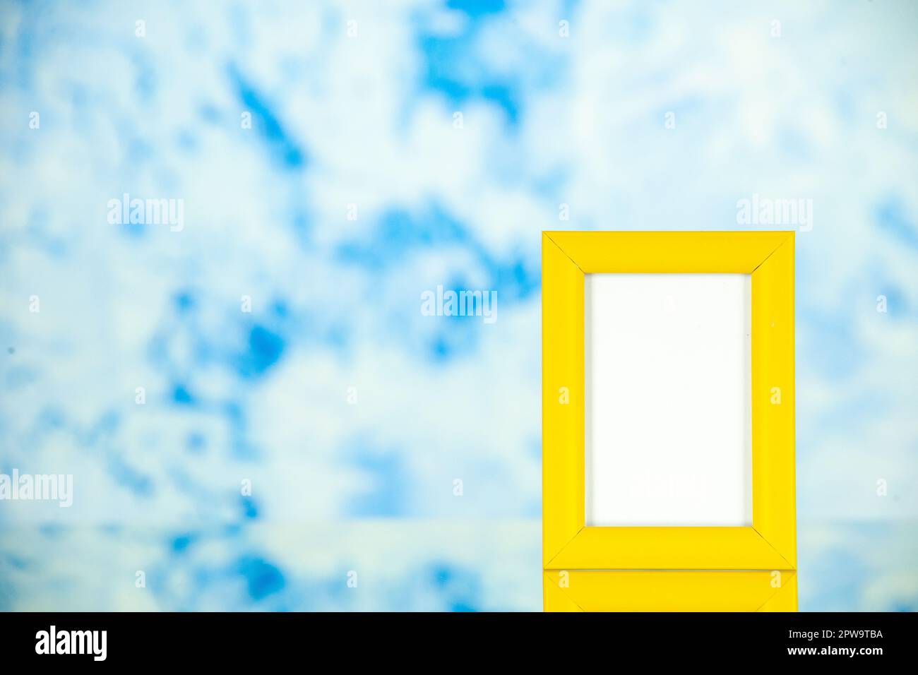 front view yellow picture frame on light-blue background portrait photo ...