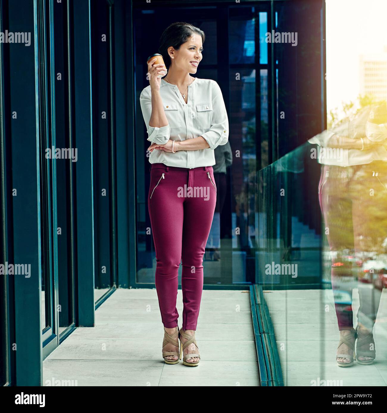 Timeout from her desk. a young businesswoman having a coffee break at ...