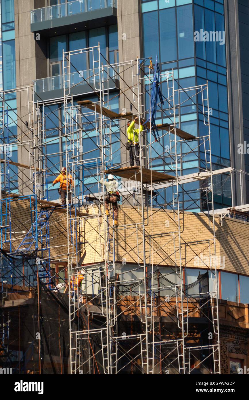 Workers constructing repointing scaffolding on an office building on ...