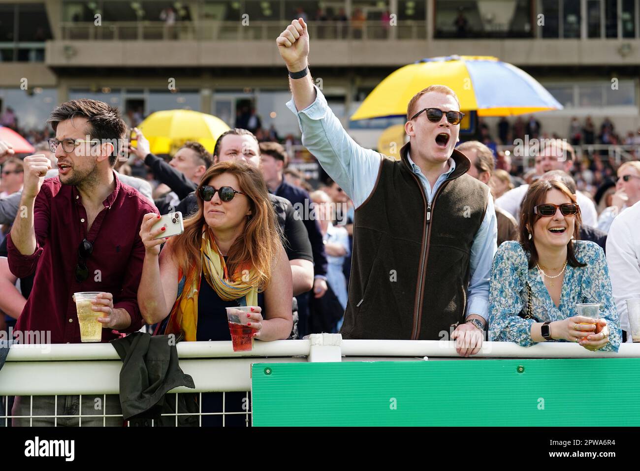 Racegoers react as they watch the action at Sandown Park Racecourse ...