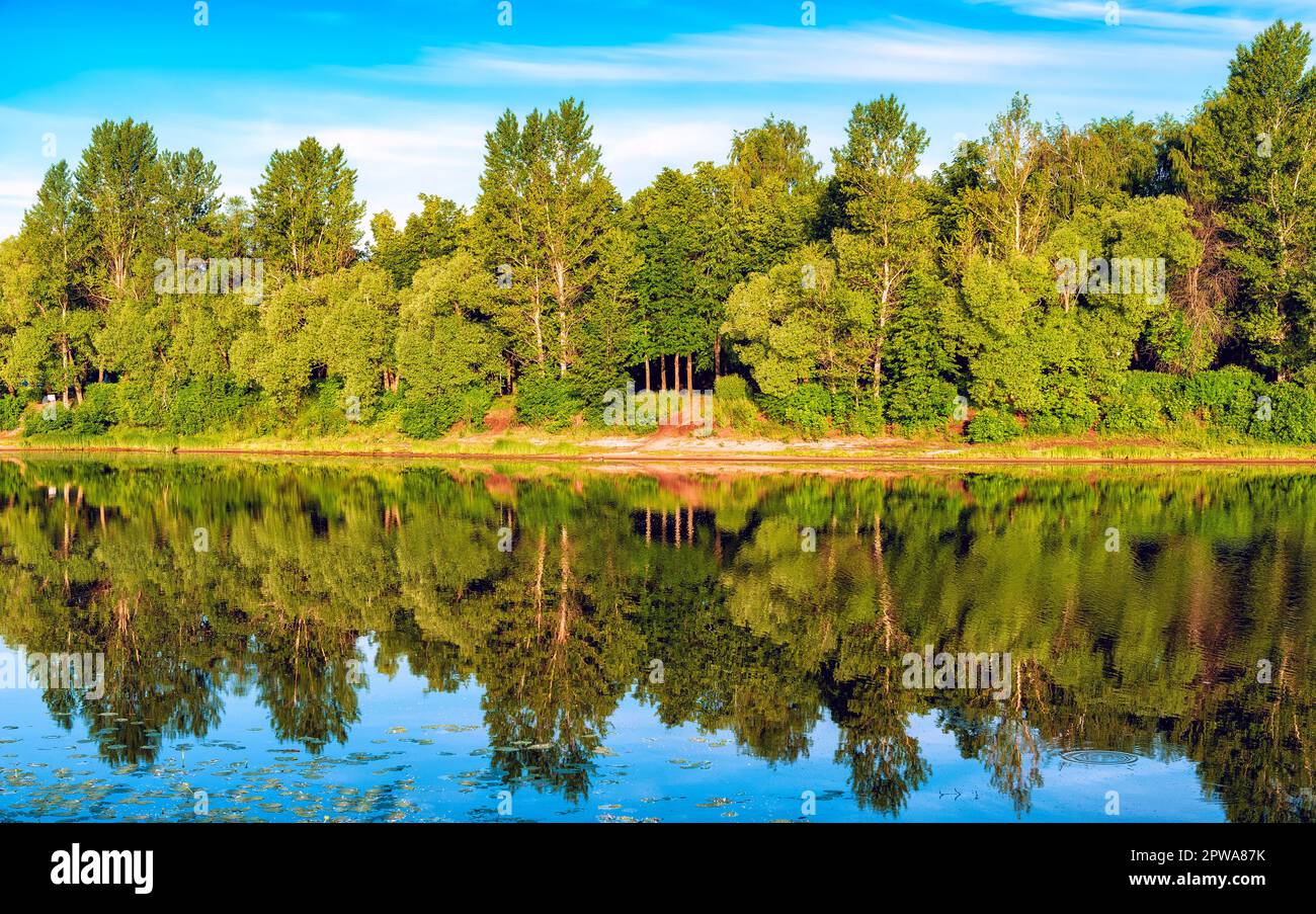 Landscape of a reservoir with reflection in the water of a forest on ...