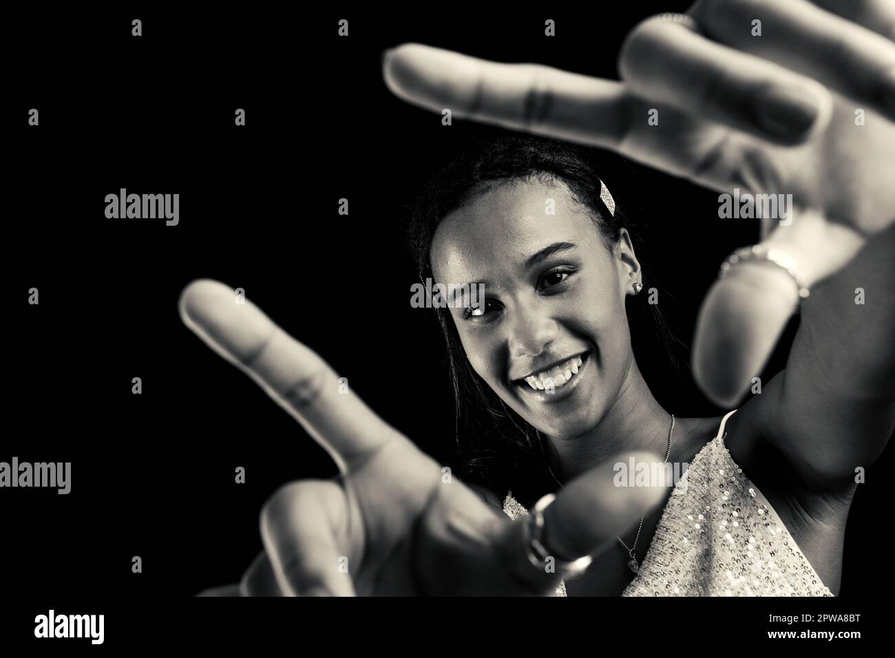 Black and white portrait of teenage girl making hand gestures at camera ...