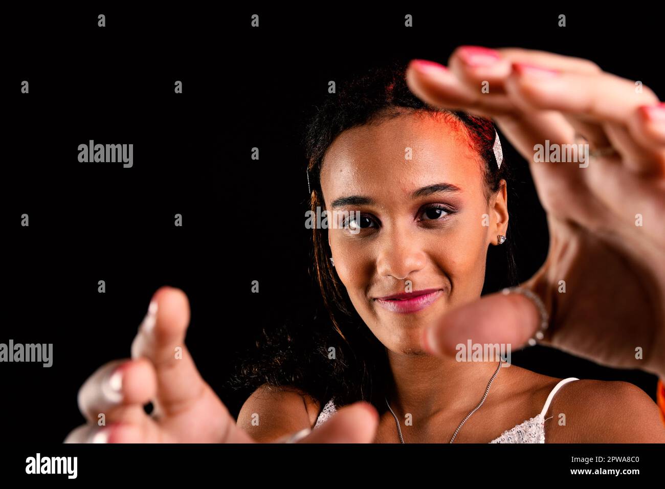 Studio portrait of pretty teenage girl making hand gestures at camera ...