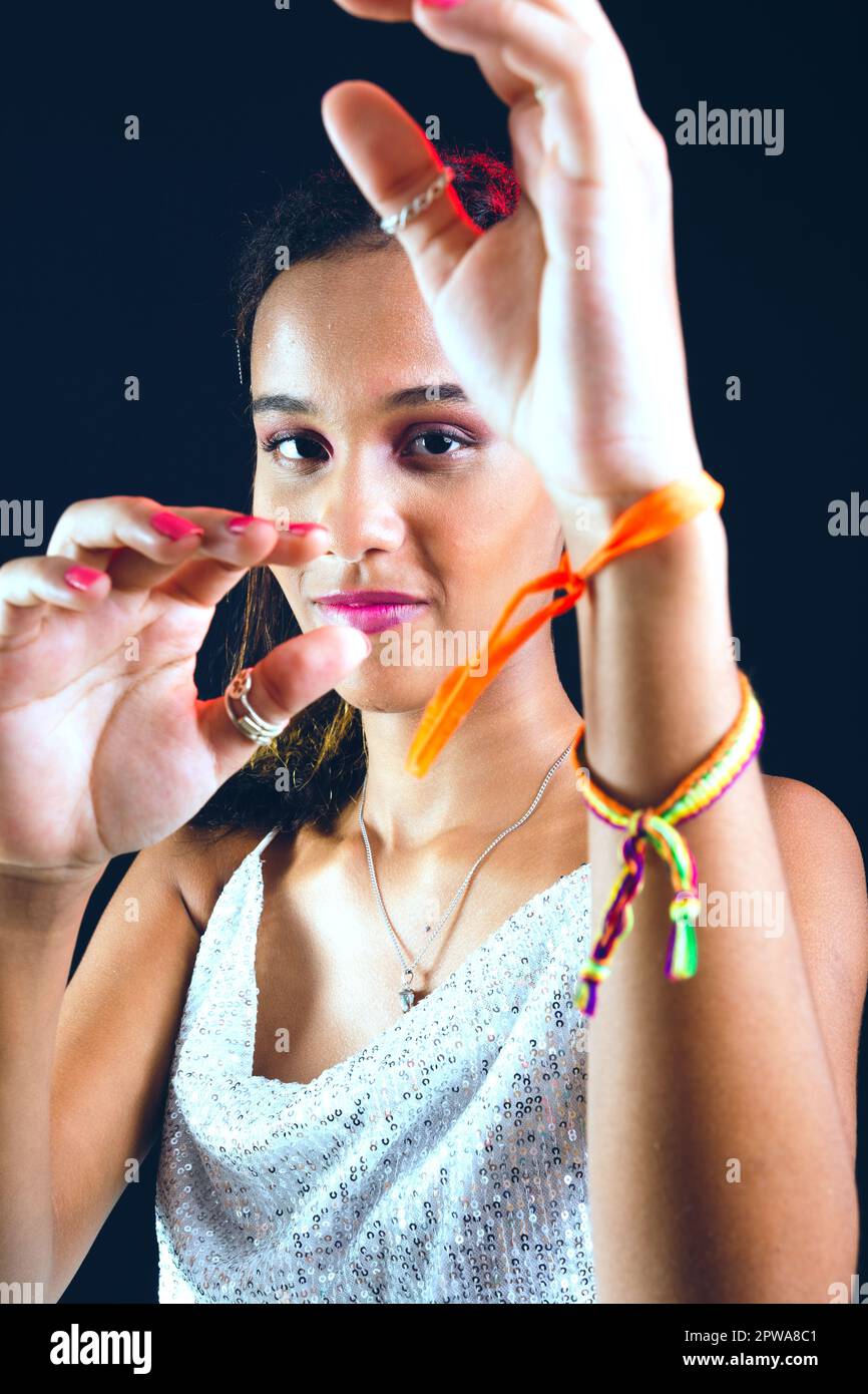 Studio portrait of pretty teenage girl making hand gestures at camera ...