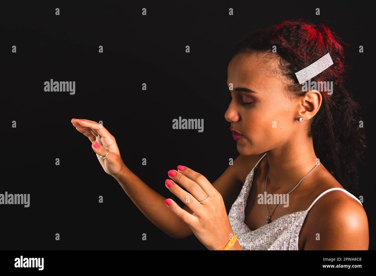 Studio portrait of pretty teenage girl making hand gestures at camera ...