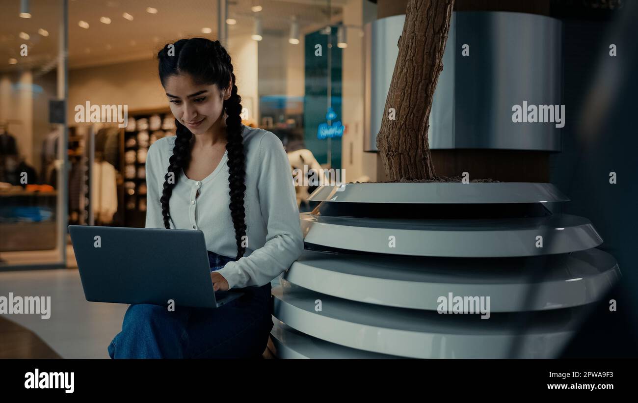 Latina businesswoman student shopper work on laptop at shopping mall ...