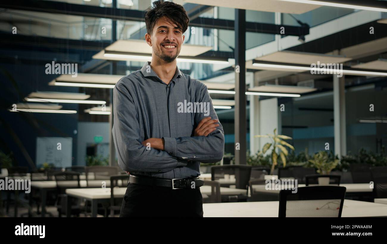 Successful smiling businessman indian arabian man posing in office with arms crossed. Confident ...